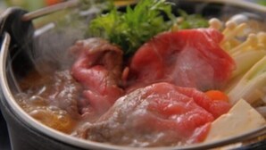 Uma panela de sopa com carne e legumes.