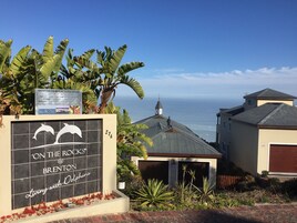 Placa para o estabelecimento 'On the Rocks', com vista para o oceano.