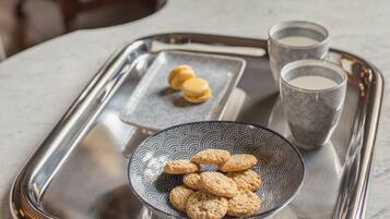 Uma bandeja com biscoitos e duas taças de leite sobre uma mesa de mármore.