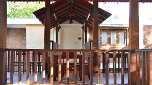 Um espaço ao ar livre coberto com um banco de madeira e vista para um edifício de tijolos.