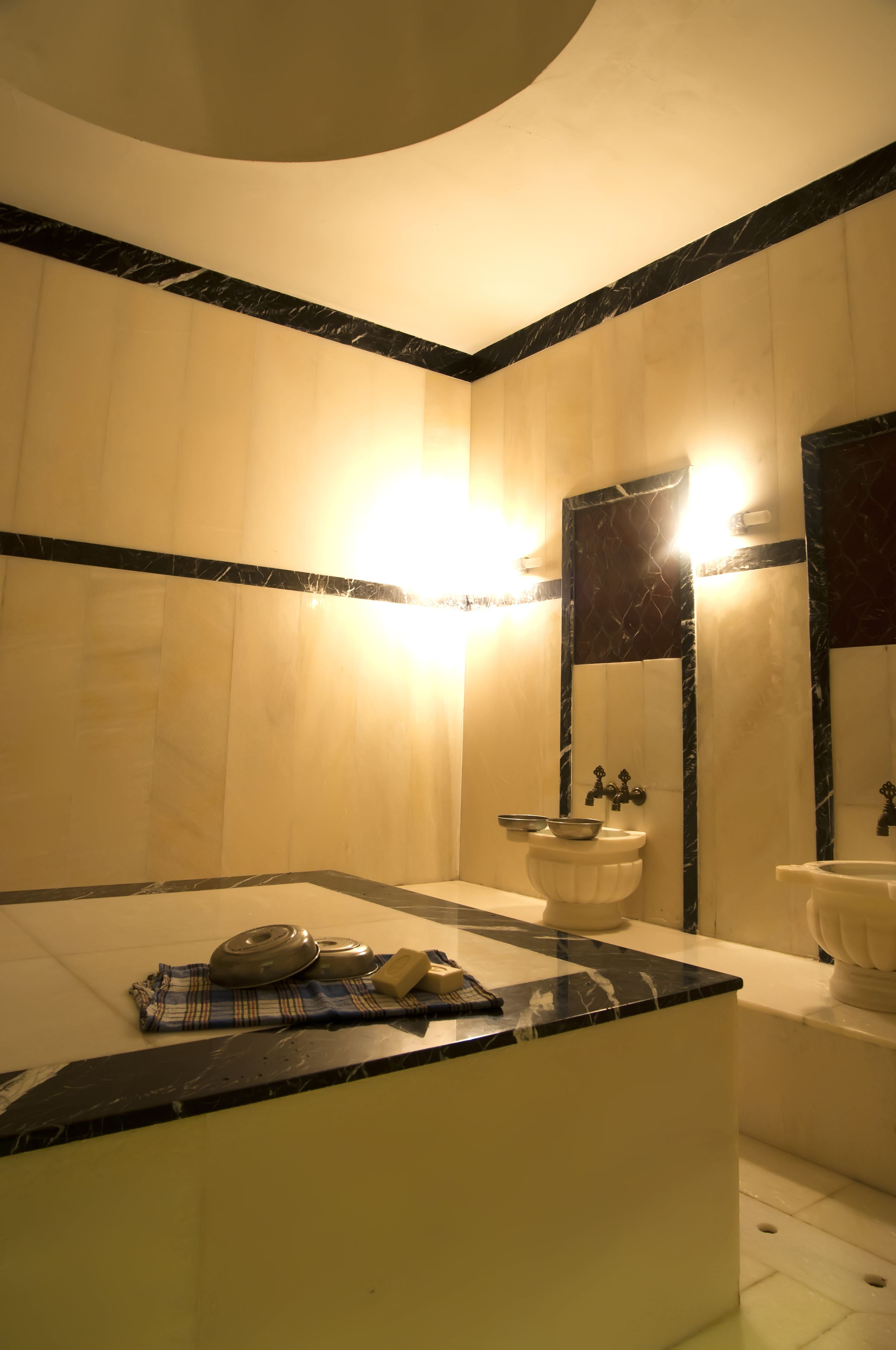 Casa de banho com bancada de mármore, lavatório e espelho.