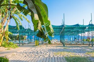 Uma praia privada, espreguiçadeiras, guarda-sóis de praia 