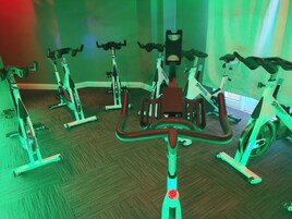 Um espaço com bicicletas ergométricas dispostas em círculo, cada uma com guidão e assento.