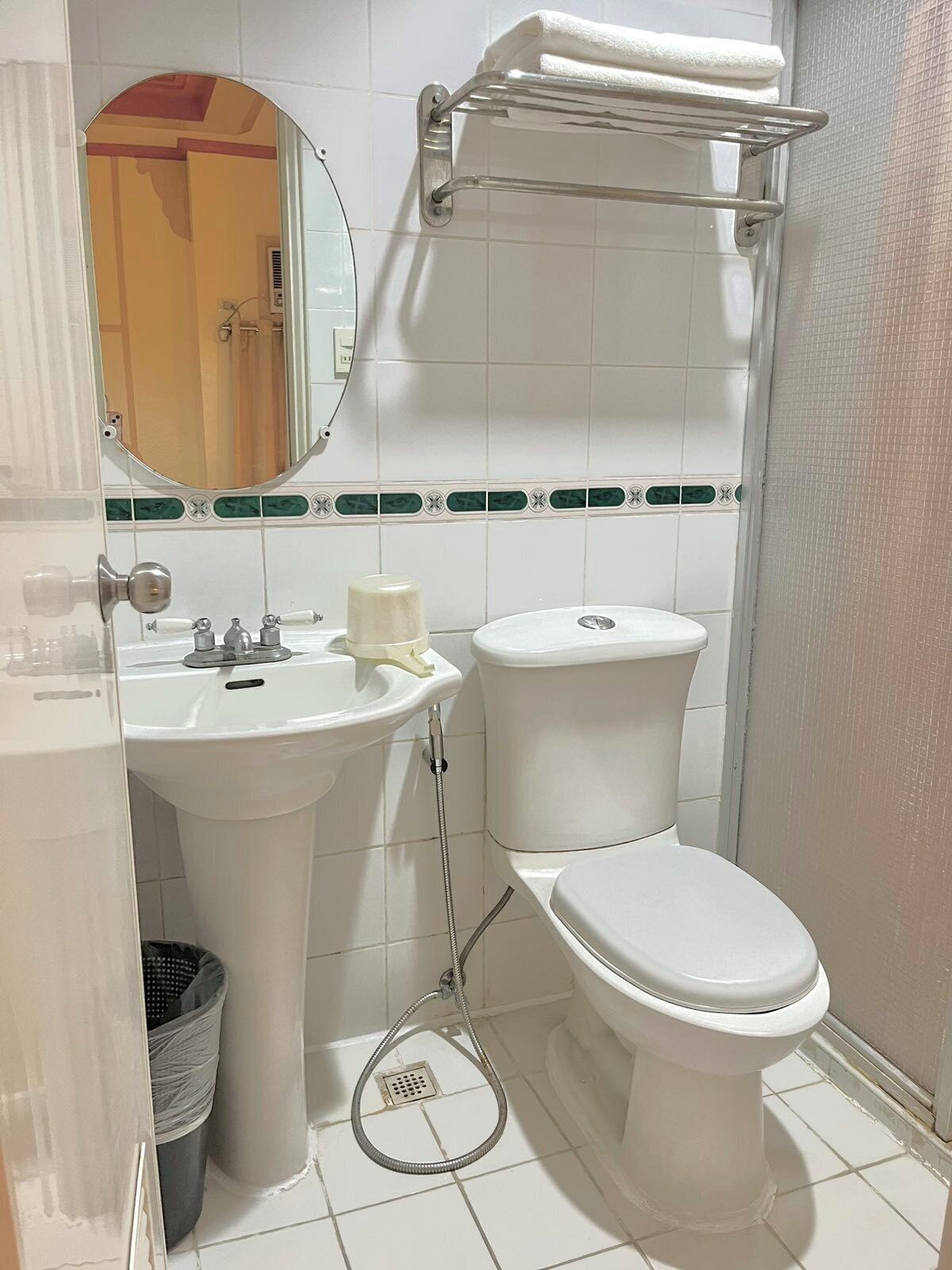 Casa de banho com lavatório, sanita e suporte para toalhas.
