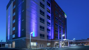 Hotel de vários andares com design moderno, destacando uma entrada imponente e uma área de estacionamento coberta.