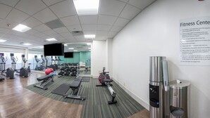 Centro de ginástica com esteiras, elípticos e pesos livres.
