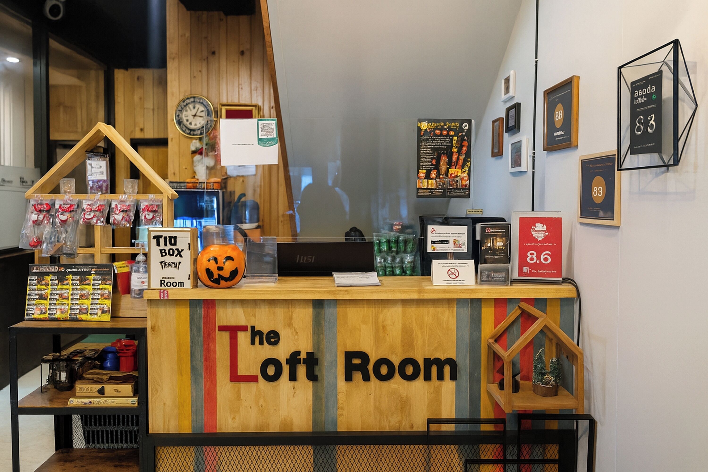 Um balcão com uma placa que diz 'The Loft Room' e diversos objetos como um relógio, quadros emoldurados e um cardápio.