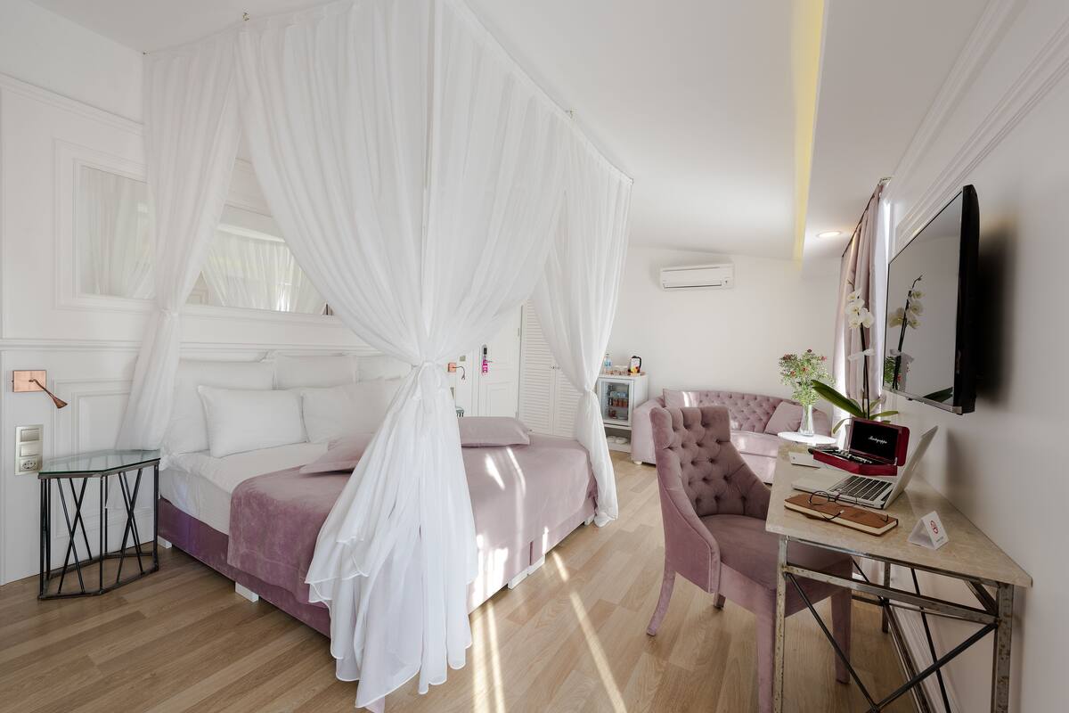 Quarto com cama, escrivaninha, cadeira e toucador com espelho.