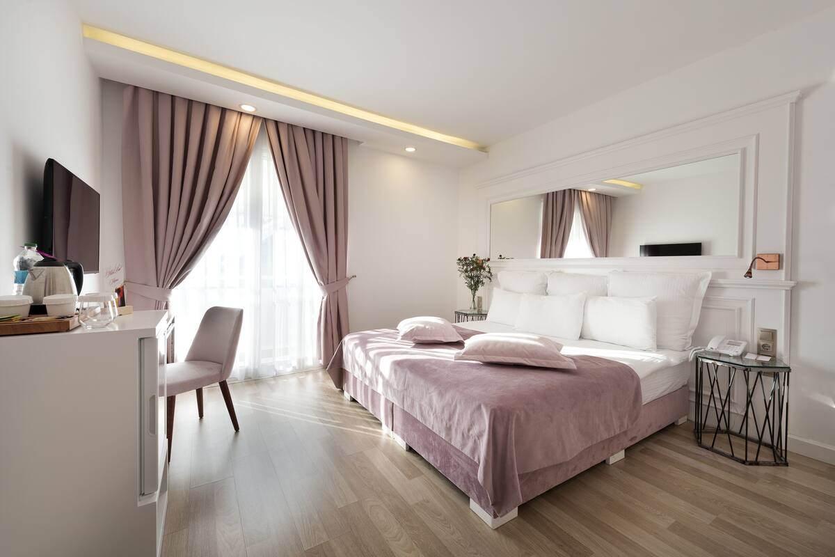 Quarto moderno com uma cama grande, uma escrivaninha e uma cadeira.