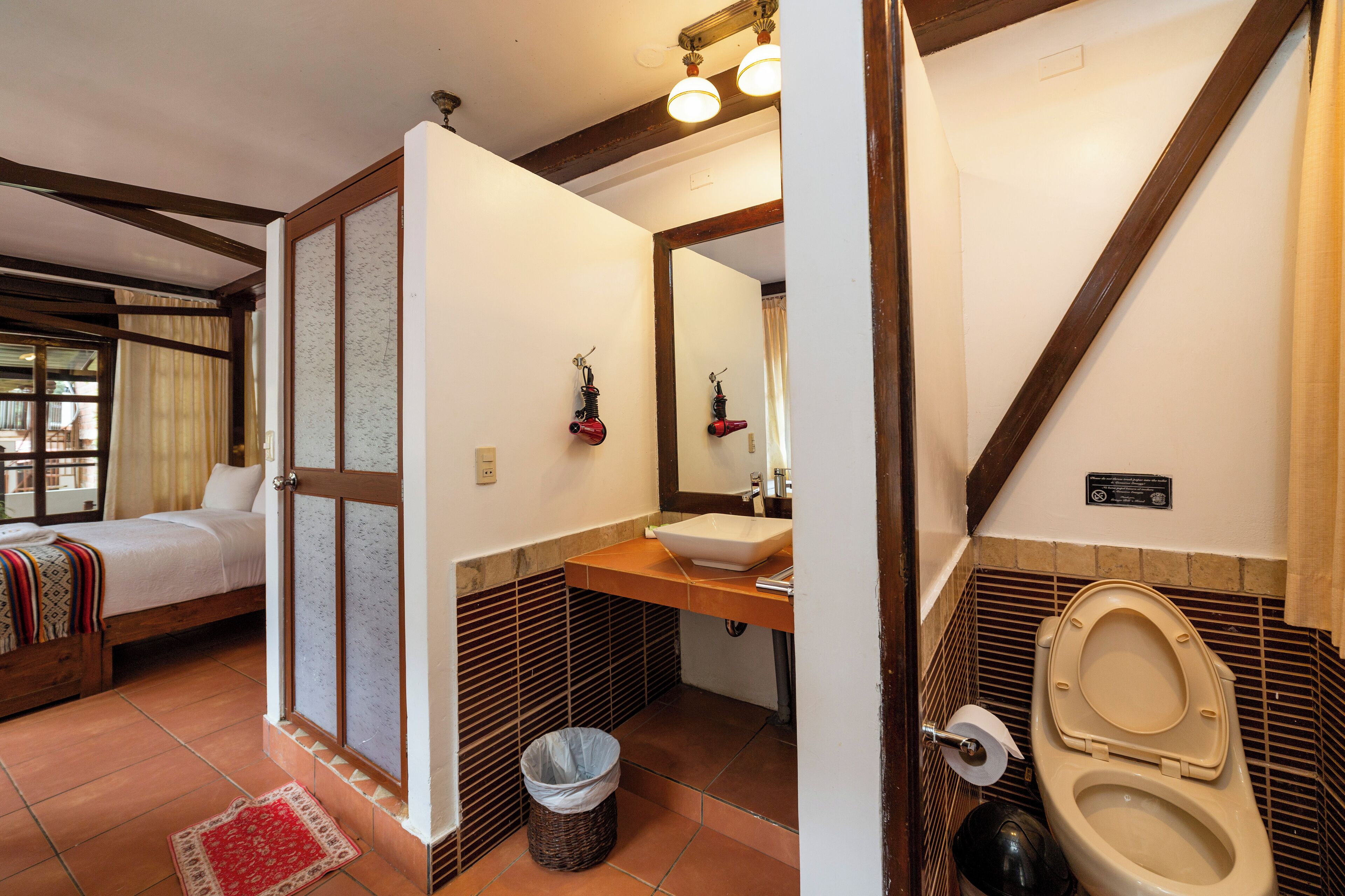 Casa de banho com sanita, lavatório e espelho.