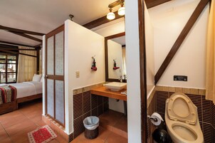 Casa de banho com sanita, lavatório e espelho.