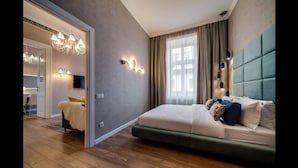 Quarto moderno com cama, espelho, lustre e vista para o exterior.