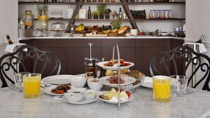 Um buffet de café da manhã com diversos alimentos e bebidas sobre uma mesa de mármore.