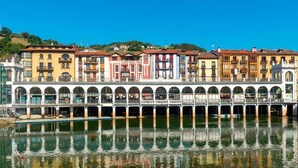 Fileira de edifícios coloridos com varandas arqueadas à beira-mar.