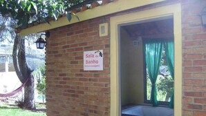 Edifício de tijolos com uma placa que diz "Sala de Banho (hidromassage)", indicando um banheiro com hidromassagem.