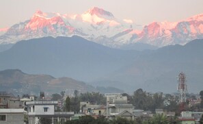 Uma cordilheira com picos nevados e uma cidade ao primeiro plano.