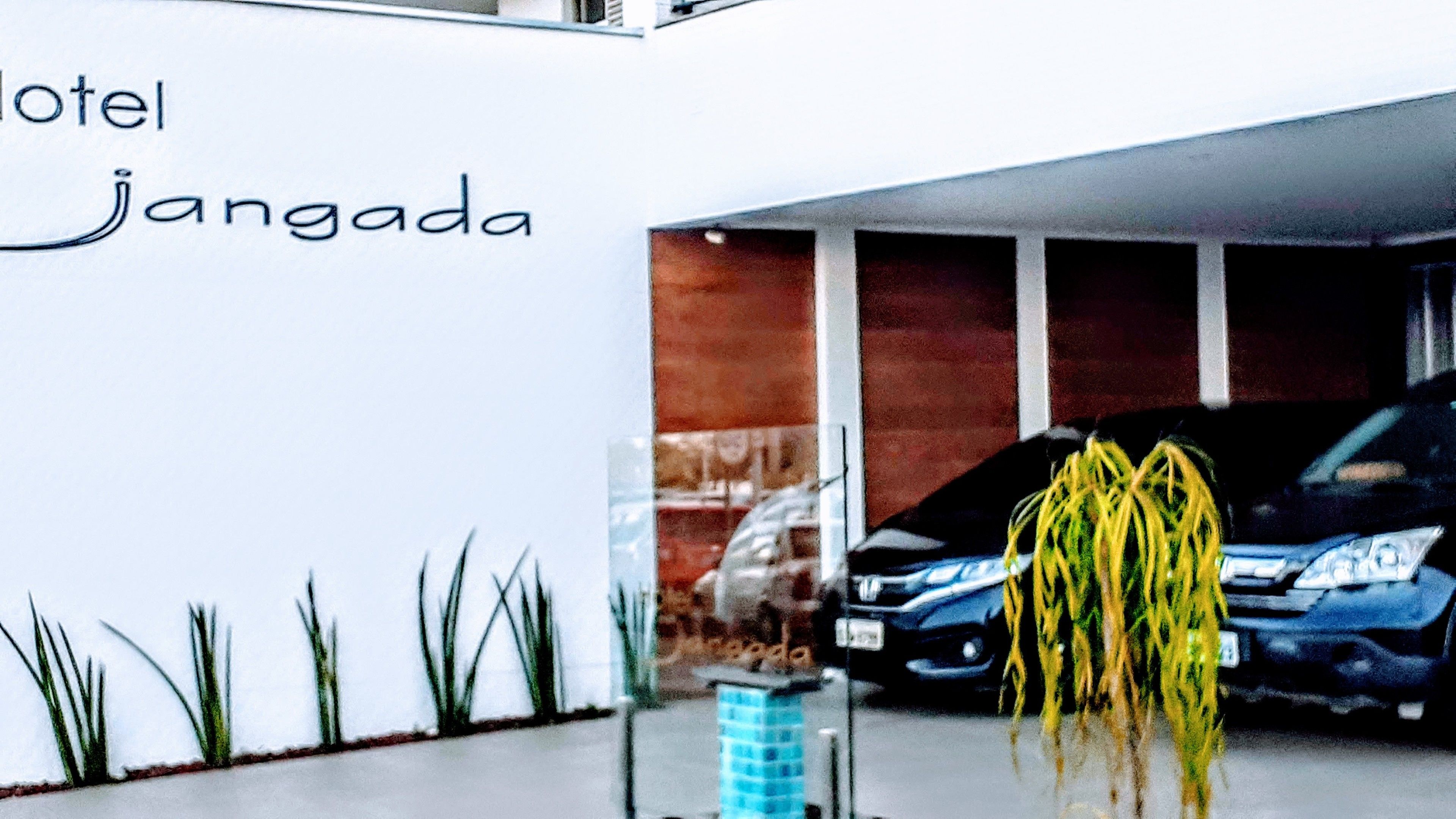 Entrada de hotel com uma placa indicando "hotel jangada".