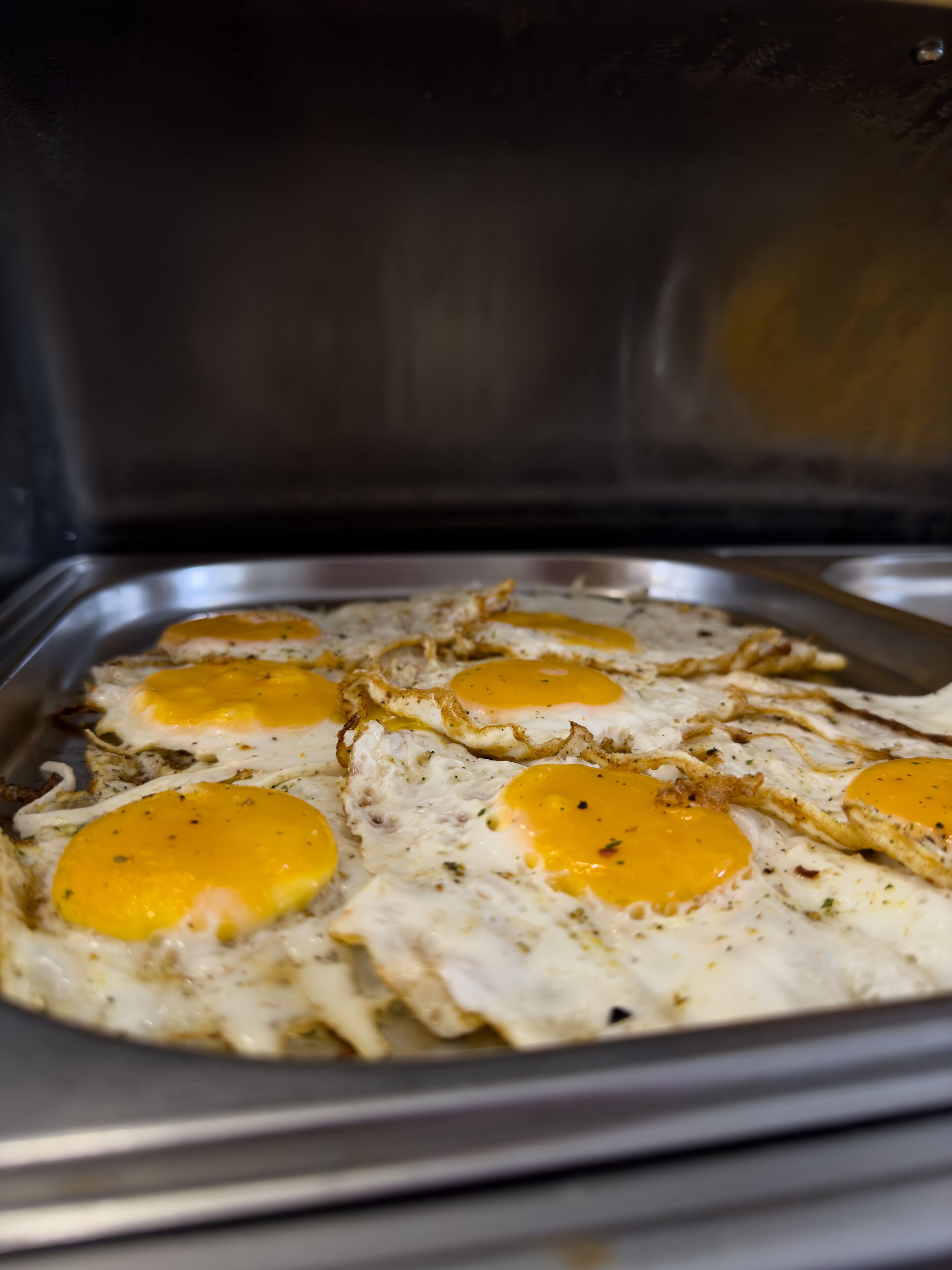Uma bandeja com ovos fritos e temperos à vista.