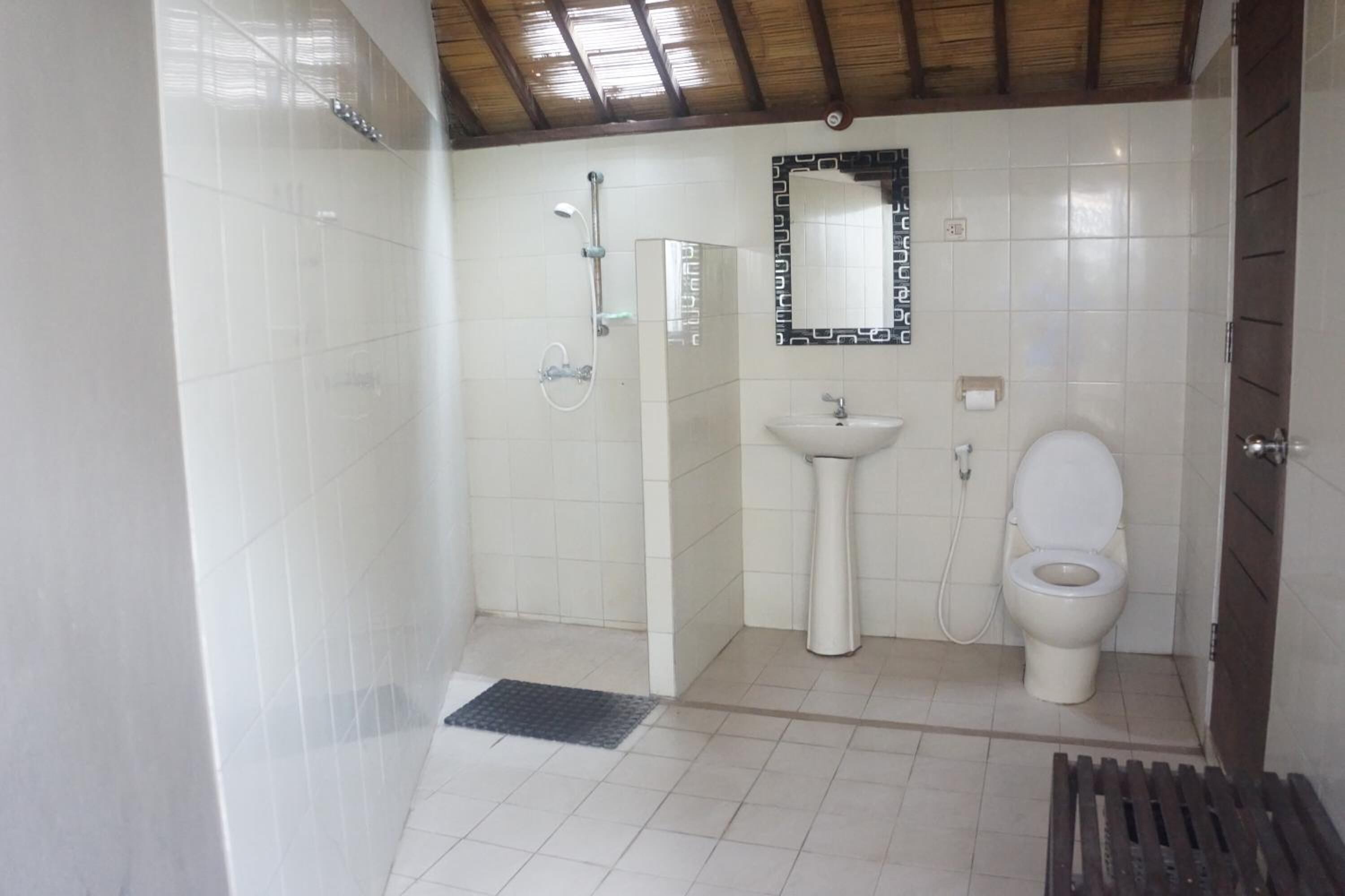 Um banheiro com chuveiro, pia e vaso sanitário.
