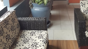 Uma área de recepção com uma planta em vaso, um sofá e uma porta com a indicação 'WiFi'.