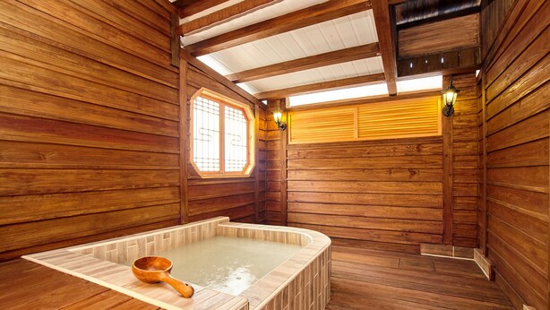 Uma sauna de madeira com um banco de madeira e uma concha de madeira.