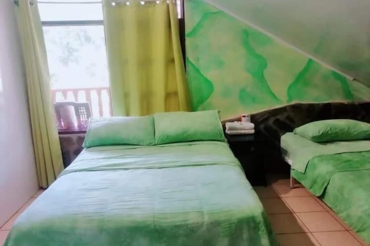 Um quarto com uma cama, uma mesa de cabeceira e uma janela com cortinas.