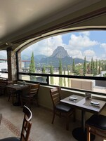 Restaurante com vista para montanhas e céu claro.