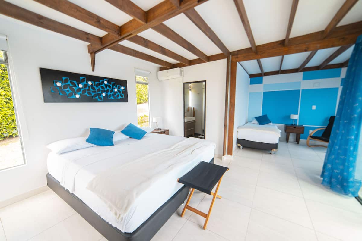 Um quarto com uma cama, uma mesinha e um espelho.