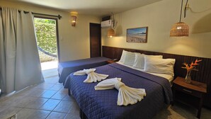 Quarto de hotel com cama, mesa de cabeceira, um quadro na parede e janela com cortinas.