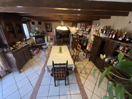Uma cozinha tradicional com uma mesa de jantar, cadeiras e diversos eletrodomésticos.