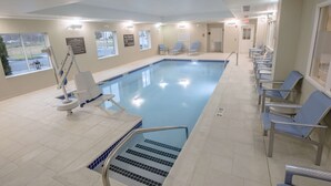 Piscina com vestiário, cadeira do salva-vidas e aviso indicando ausência de salva-vidas.