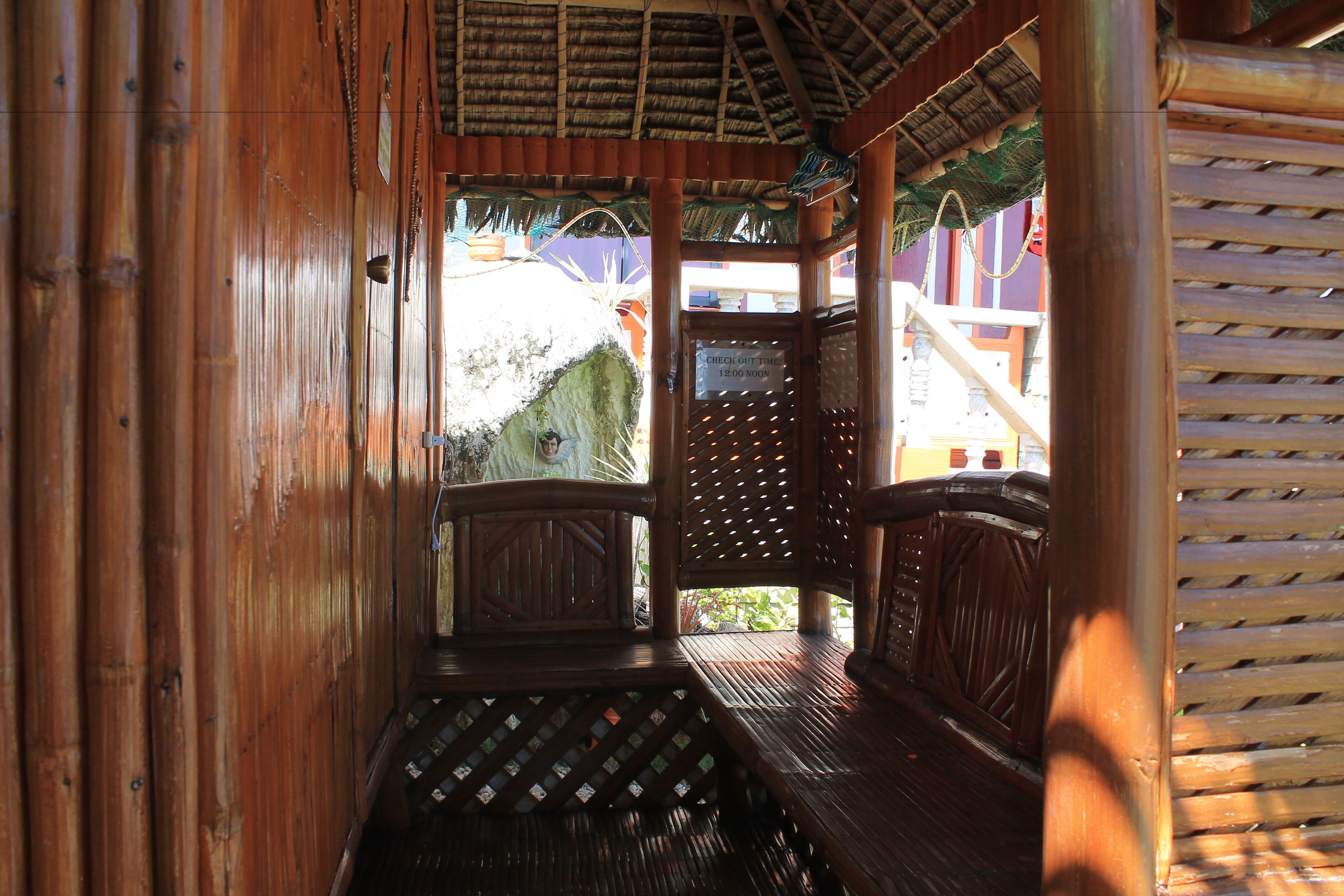 Interior em madeira com balcão de recepção e vista para o exterior.