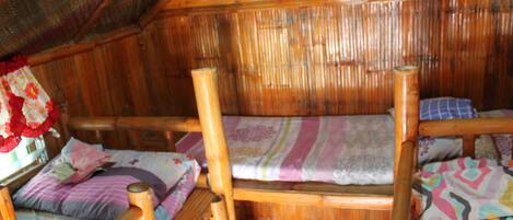 Quarto de madeira com beliches e teto de tear.