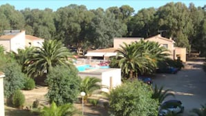 Uma área residencial com casas, piscina e palmeiras.
