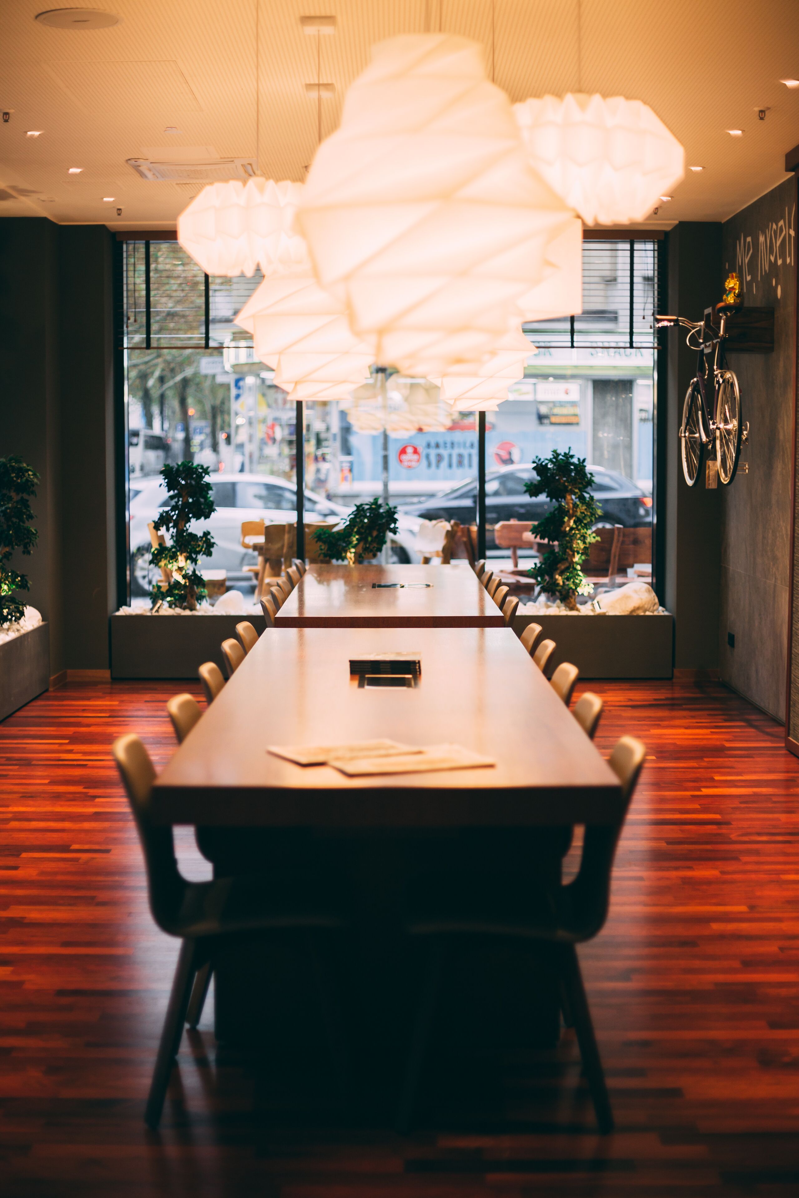 Uma sala de conferências com uma mesa comprida, cadeiras e uma grande janela com vista para a rua.