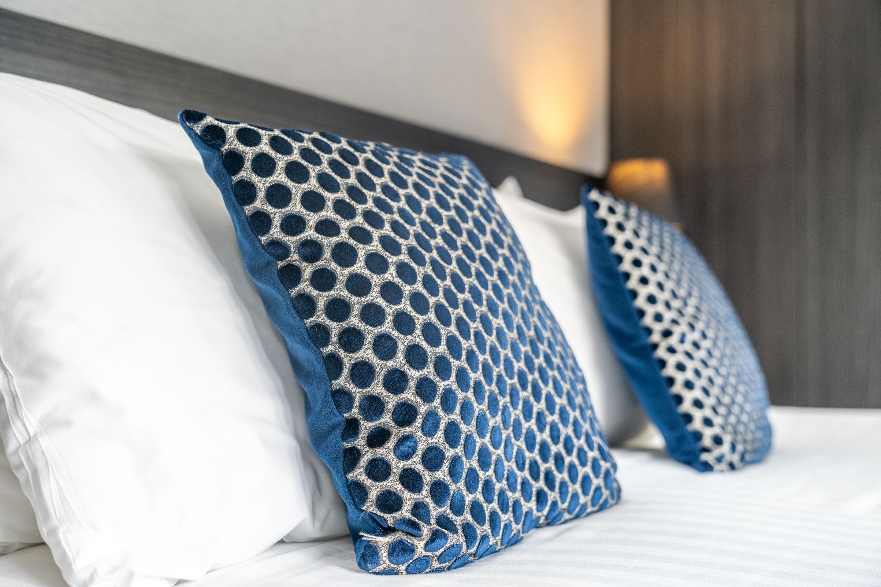 Uma cama com almofadas estampadas em branco e azul.