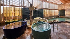 Um onsen japonês tradicional com várias banheiras termais e decoração em madeira.