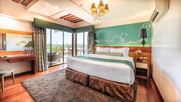 Quarto de hotel moderno com uma cama grande, uma escrivaninha e varanda com vista.