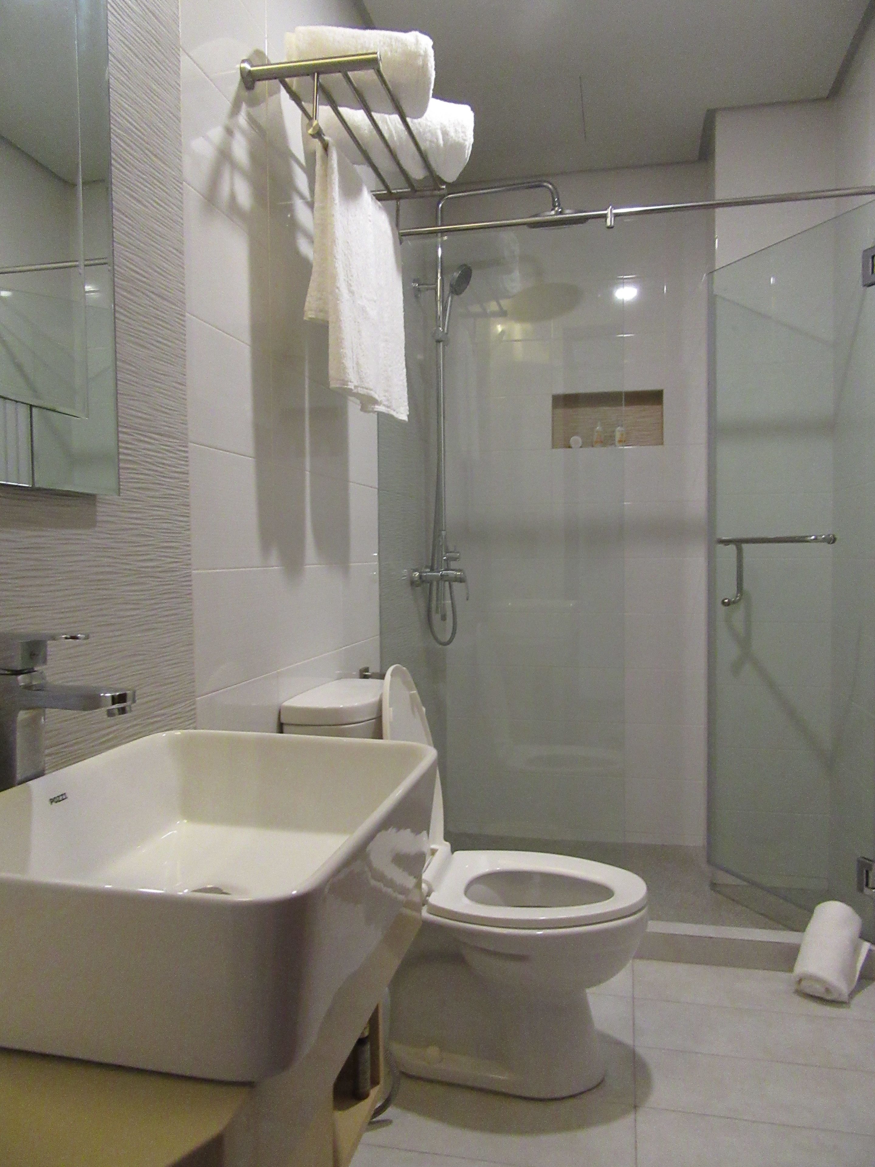 Um banheiro moderno com banheira, vaso sanitário e box de vidro.