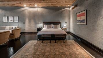 Um quarto espaçoso com uma cama grande, um ventilador de teto e uma bandeira emoldurada na parede.