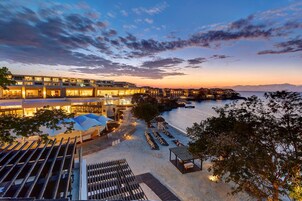 Hotel com área de piscina, espaço para sentar ao ar livre e vista para o mar.