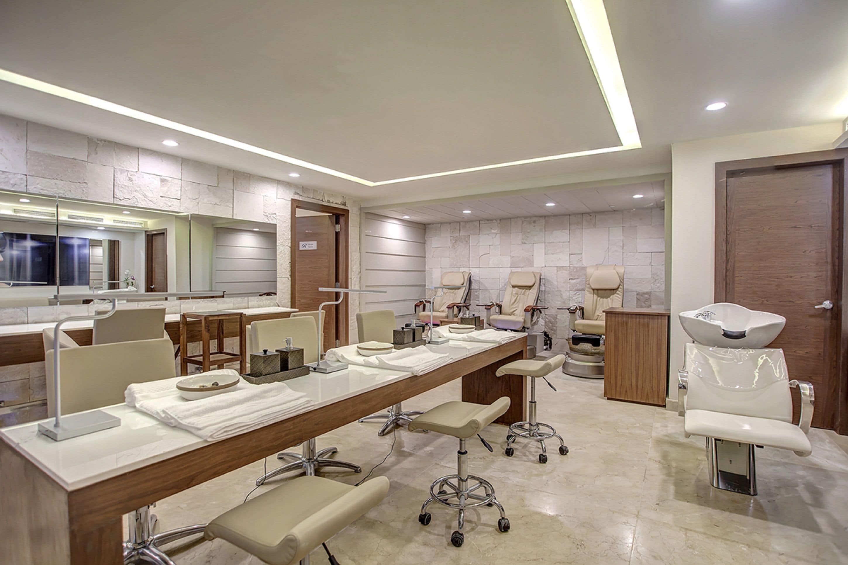 Uma clínica dentária moderna com um balcão de receção extenso, várias cadeiras de dentista e um interior limpo e bem iluminado.