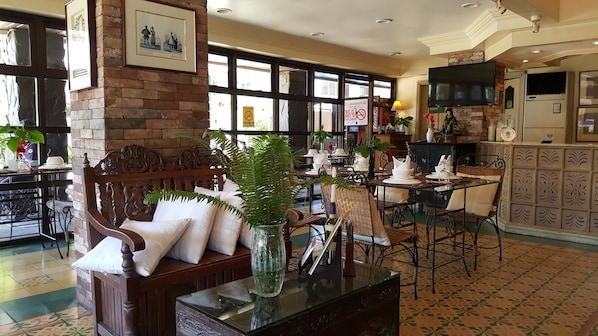 Um restaurante acolhedor com paredes de tijolo, mobiliário de madeira e chão de azulejos.