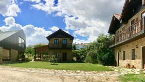 Um bairro residencial com edifícios de pedra, entrada pavimentada e gramado bem cuidado.