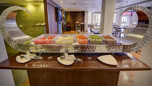 Um balcão de buffet com vários recipientes de comida e utensílios.