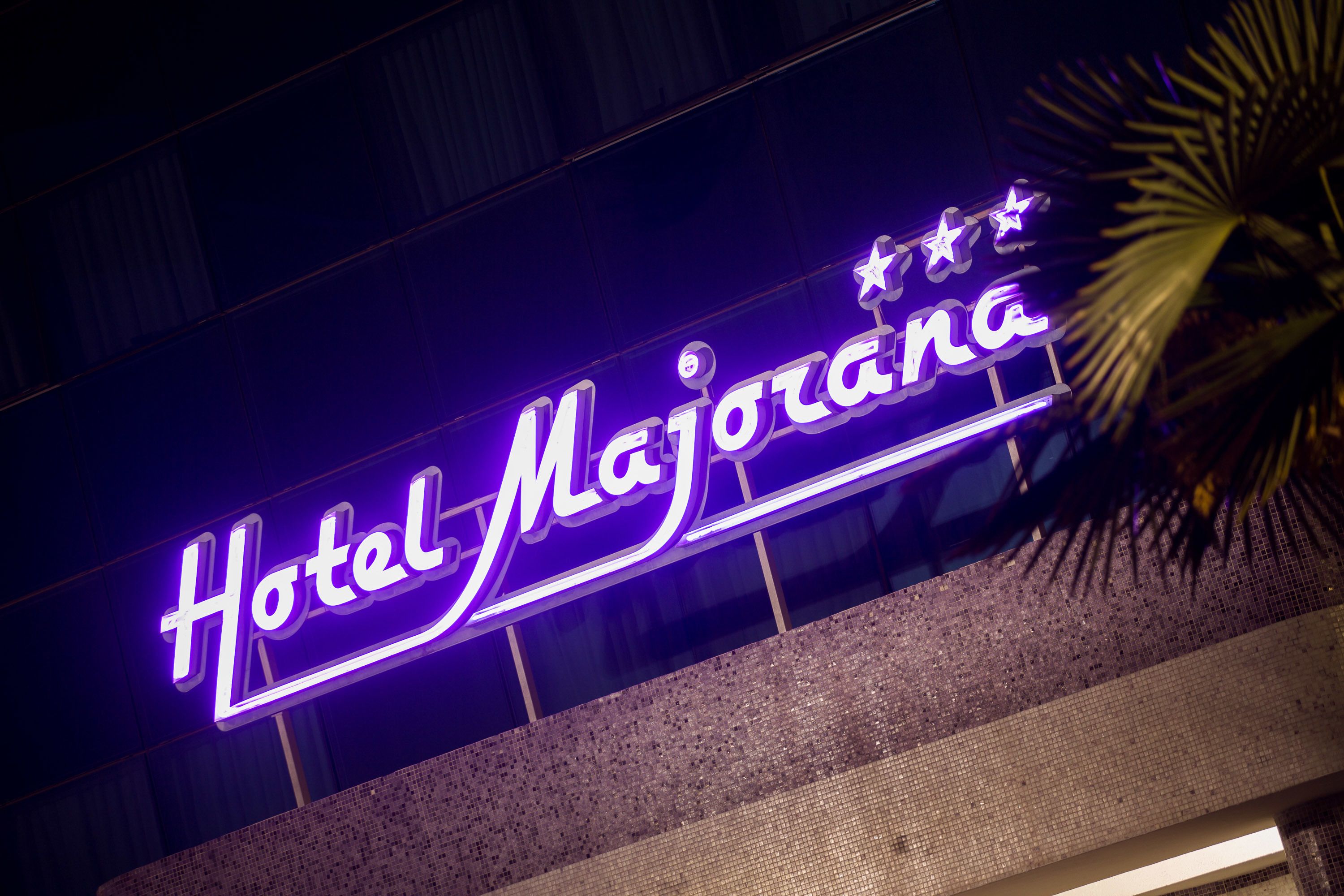 Letreiro de neon do 'Hotel Majorana' com decoração em formato de estrela.