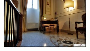 Um quarto com um piano, uma escrivaninha, um abajur e uma cadeira.