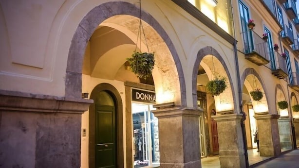 Um edifício com entradas em arco e plantas penduradas.