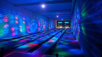 Uma pista de boliche com várias pistas e iluminação colorida.