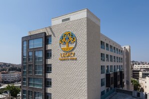 Edifício de hotel com um logotipo marcante e o nome "Legacy" na fachada.
